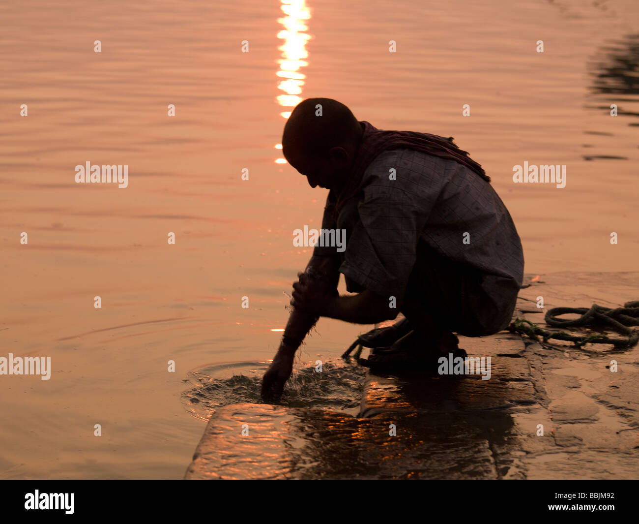 Man washing his hand in the Ganges River in India Stock Photo - Alamy