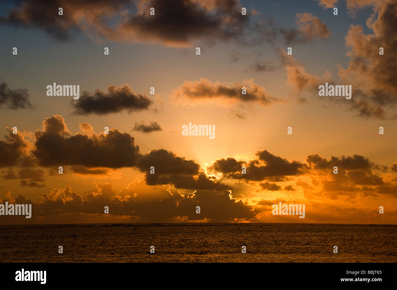 Sun setting behind dark Clouds over South Pacific Ocean Rarotonga Cook ...