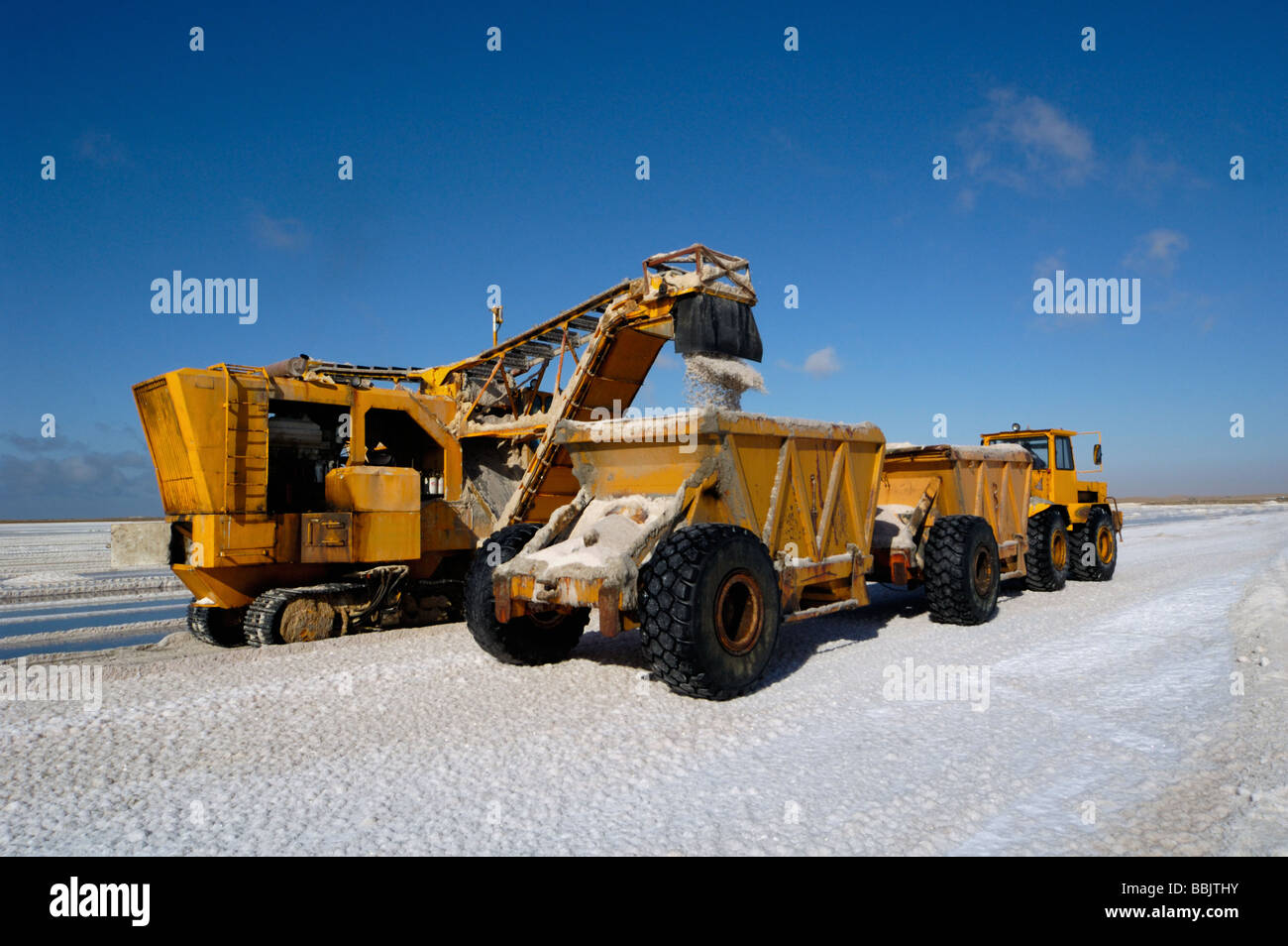 Machine harvesting of salt from sea water evaporation pans Stock Photo ...