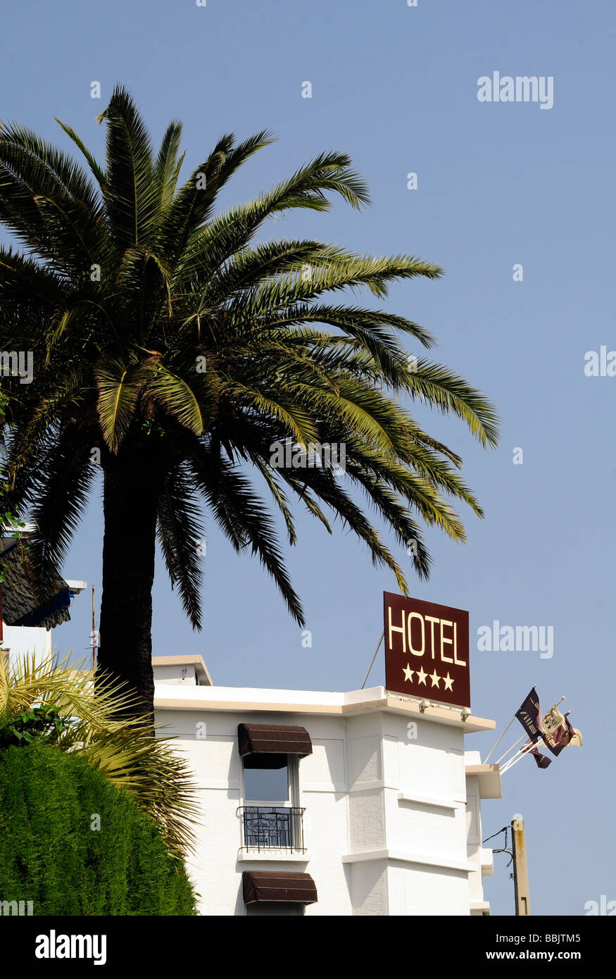 A Four Star Hotel Sign Against A Blue Sky And Palm Tree Background In