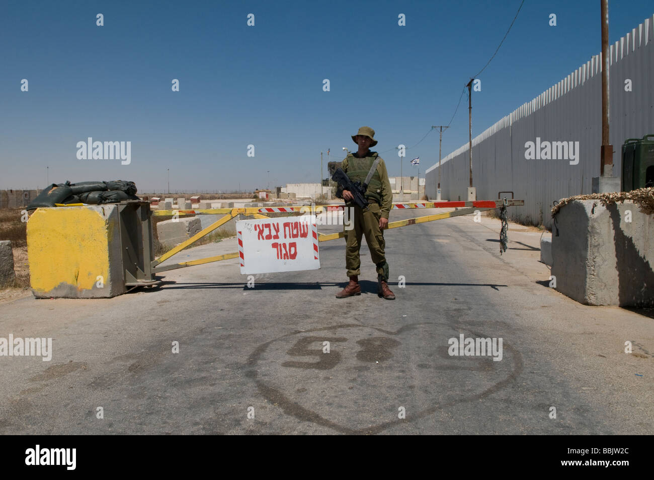 An Israeli soldier stands guard in a closed military zone near Kerem ...