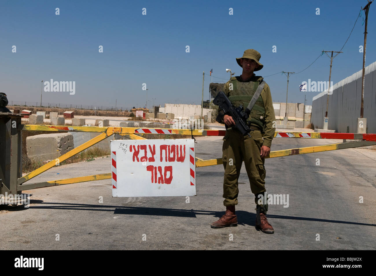 An Israeli soldier stands guard in a closed military zone near Kerem ...