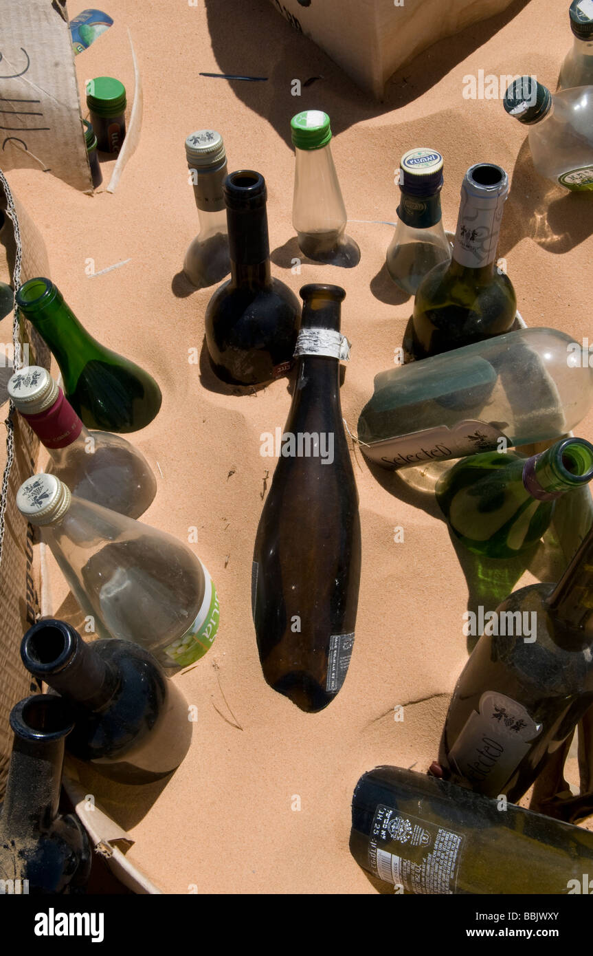 Stack of empty bottles in the sand Stock Photo - Alamy