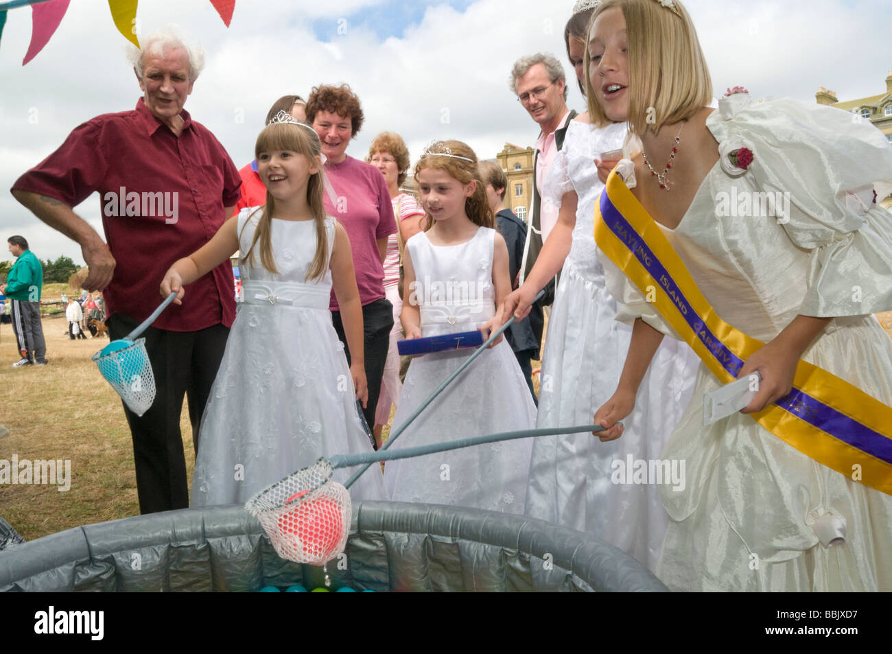 Carnival Queen and Princesses try netting prizes on a stall at the fair ...