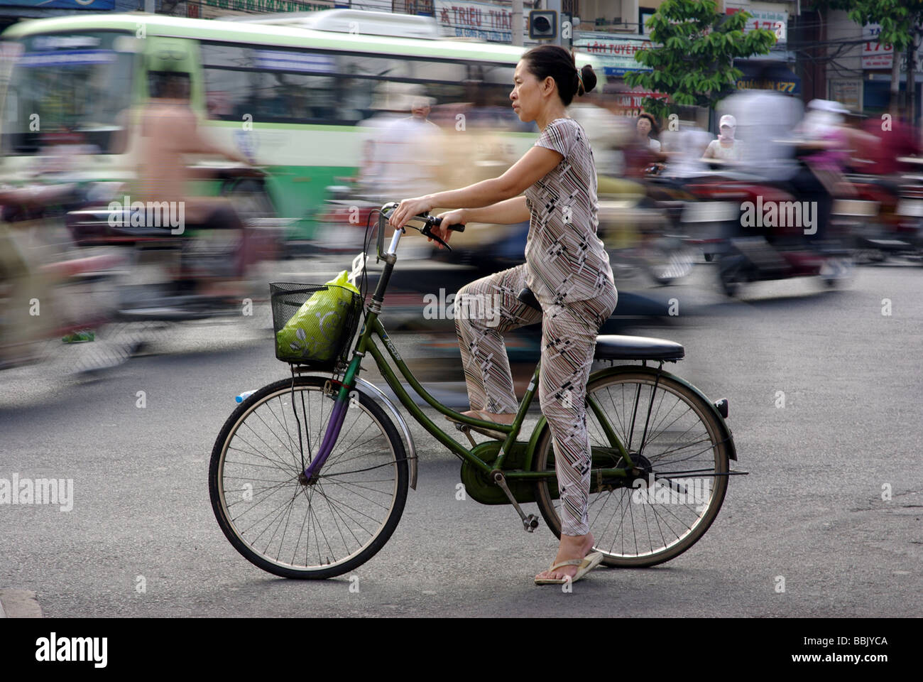 Cycle riders struggle to cross the road during rush-hour in Ho Chi Minh ...