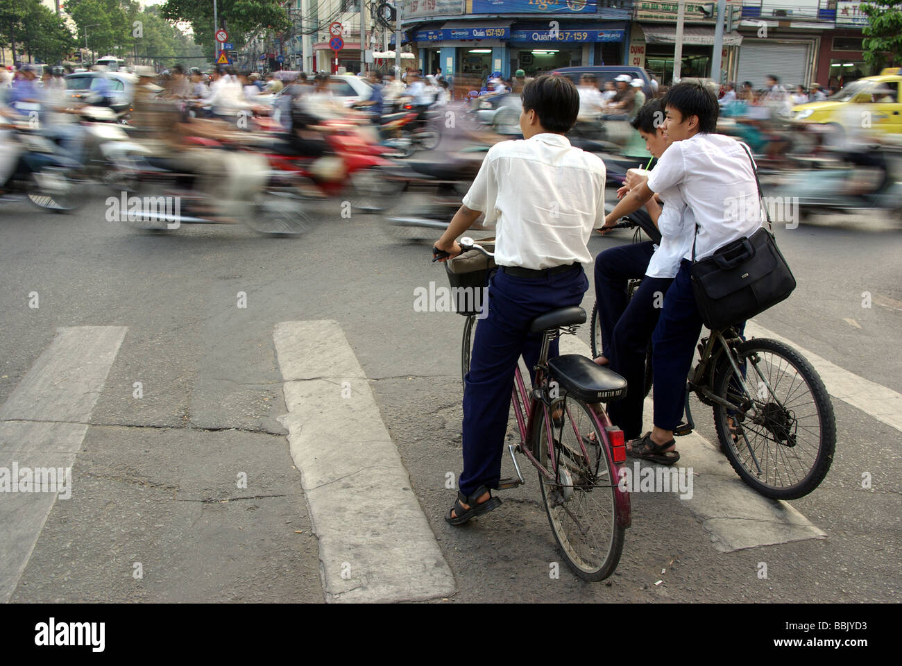 Cycle riders struggle to cross the road during rush-hour in Ho Chi Minh ...