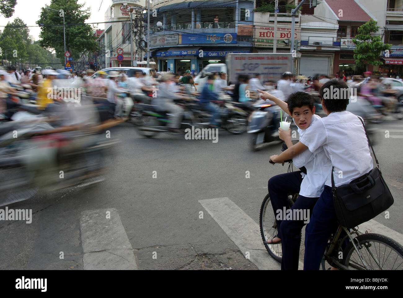 Cycle riders struggle to cross the road during rush-hour in Ho Chi Minh ...