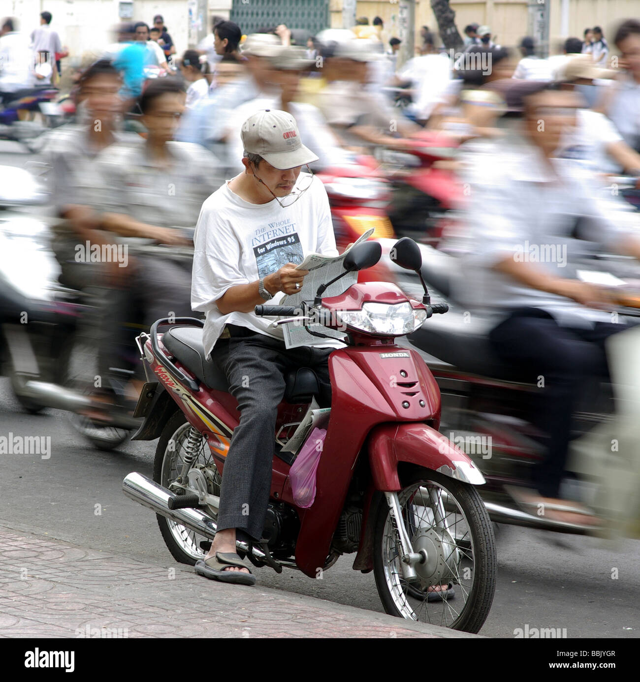 Reading a newspaper - relaxing on a motorbike in Ho Chi Minh City ...