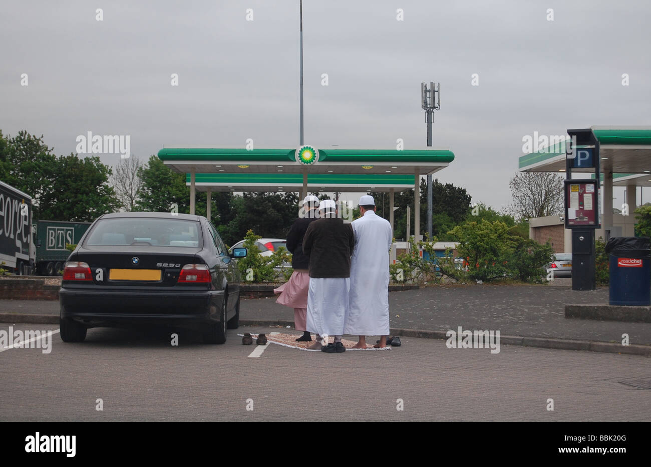 Muslim men praying in a car park at a service station near Coventry ...