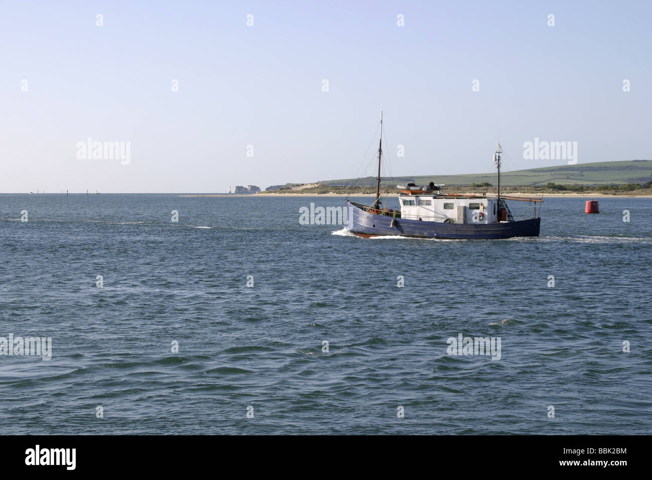 A small fishing boat sets to sea from Sandbanks in Dorset UK Stock ...