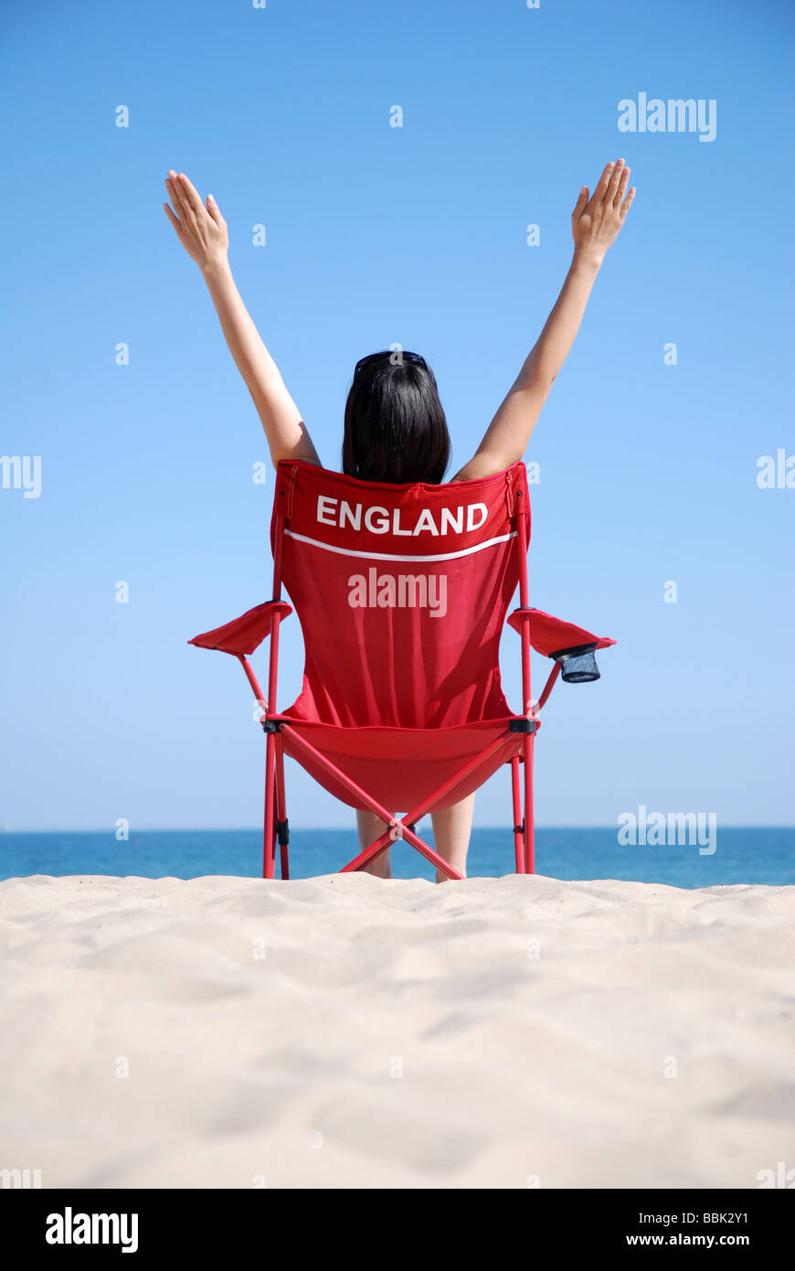Lady cheering on deckchair at the beach Stock Photo - Alamy