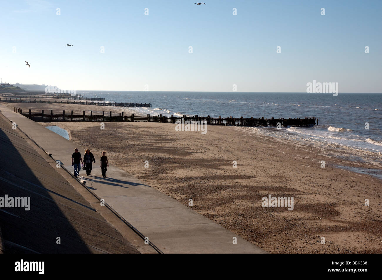 Early evening walk along the beach at Walcott, Norfolk, UK Stock Photo ...