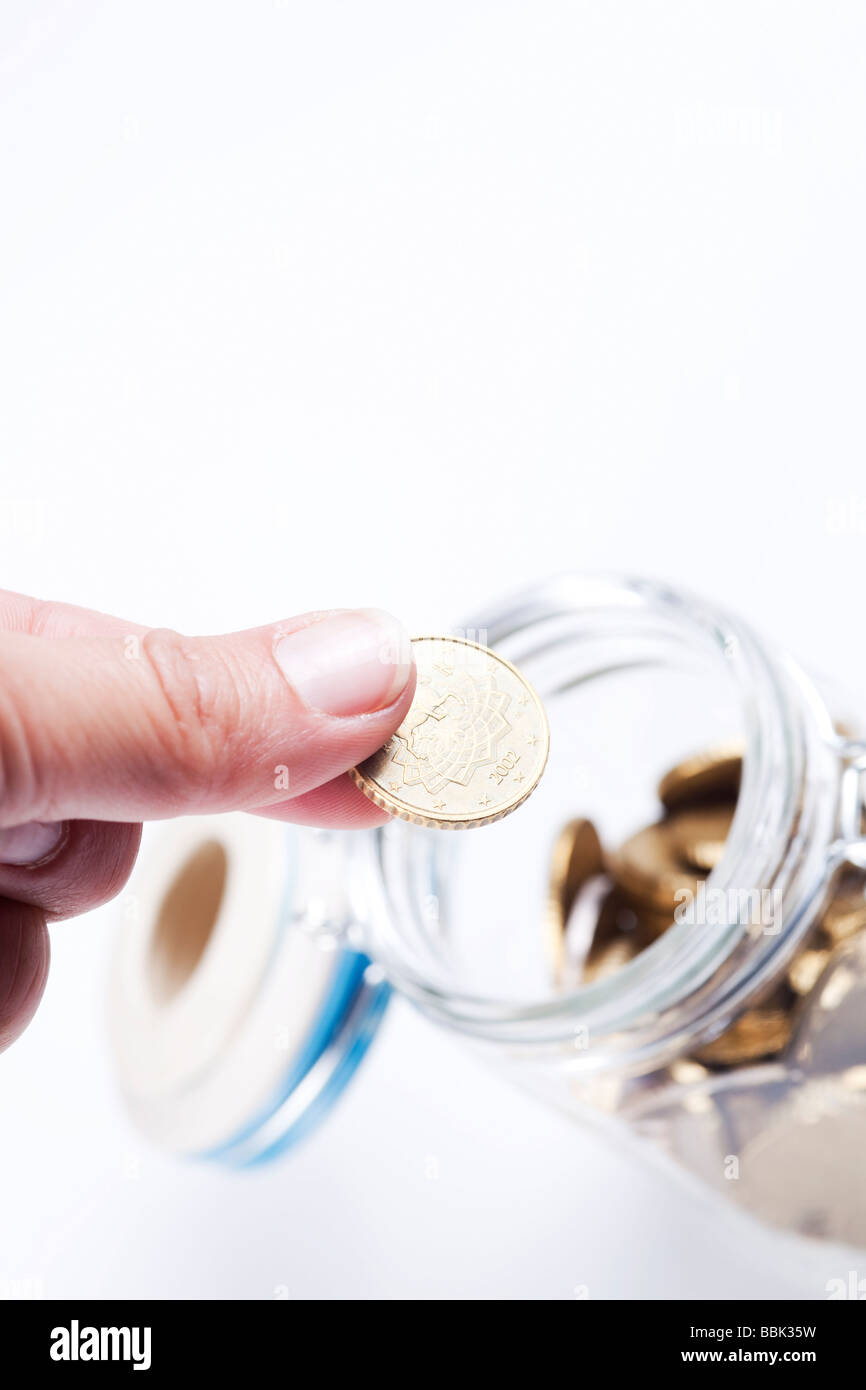 HAND THROWING MONEY INTO AN OPEN JAR Stock Photo - Alamy