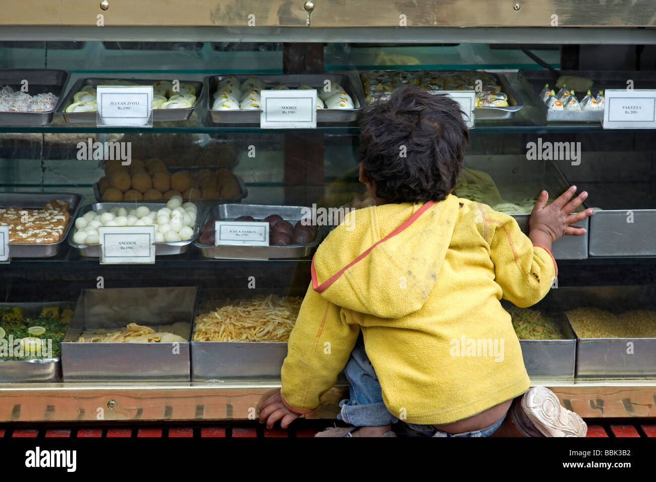 Poor girl looking at the bakery sweets. Shimla. Himachal Pradesh. India ...