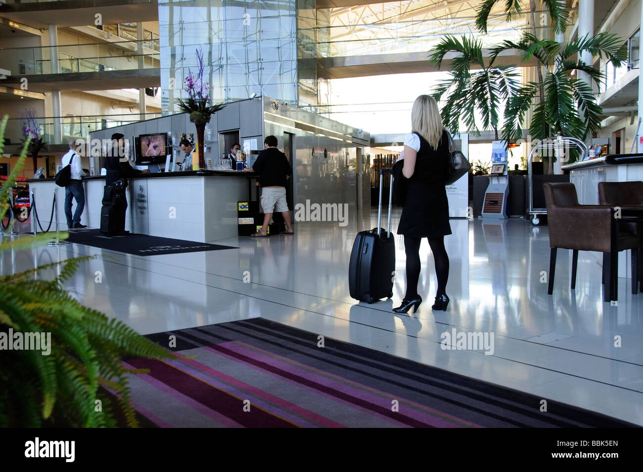 Hotel lobby reception and check in desk woman dressed in black with a ...