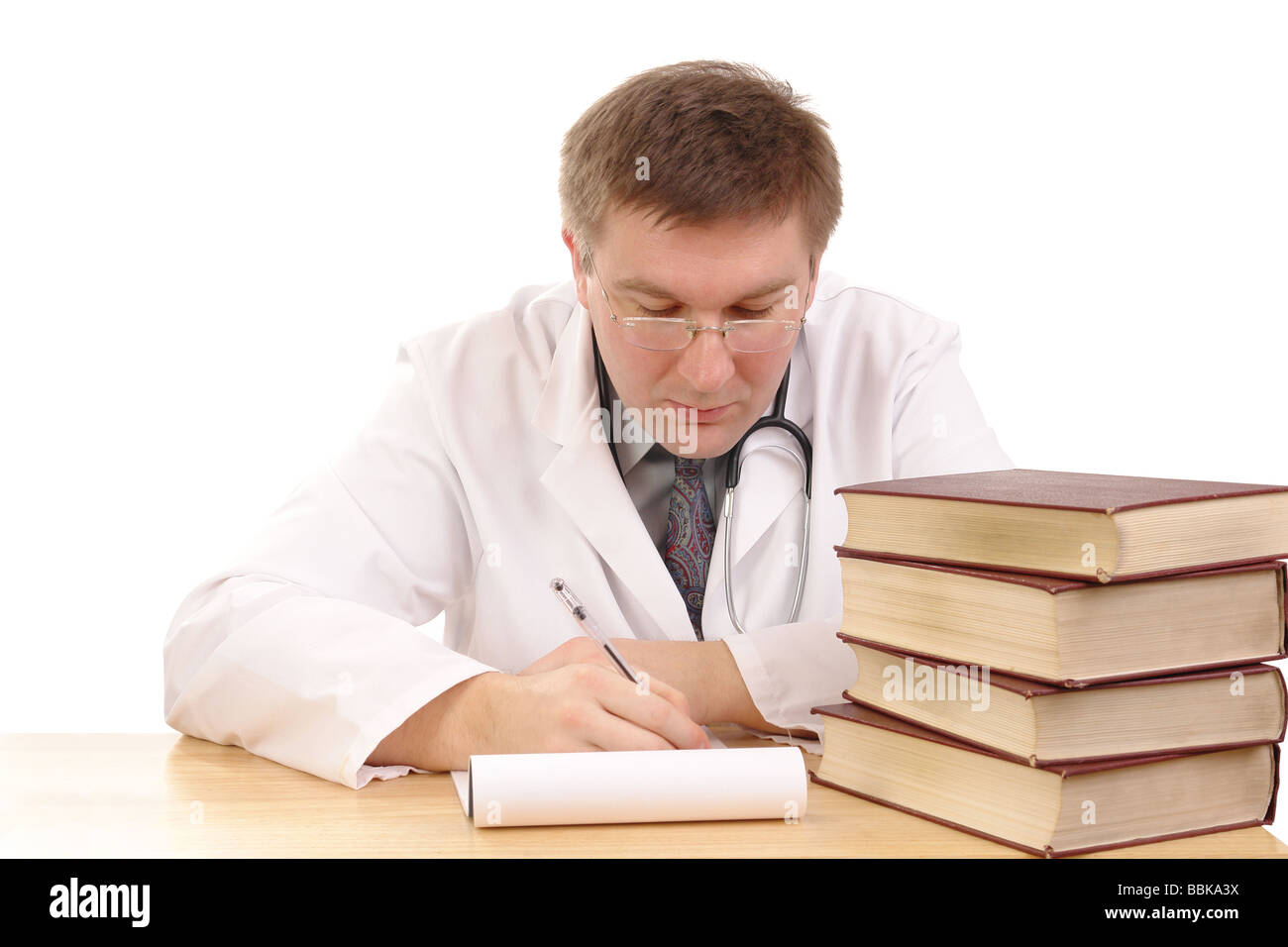 Young male doctor studying medical books and taking notes - shot over ...