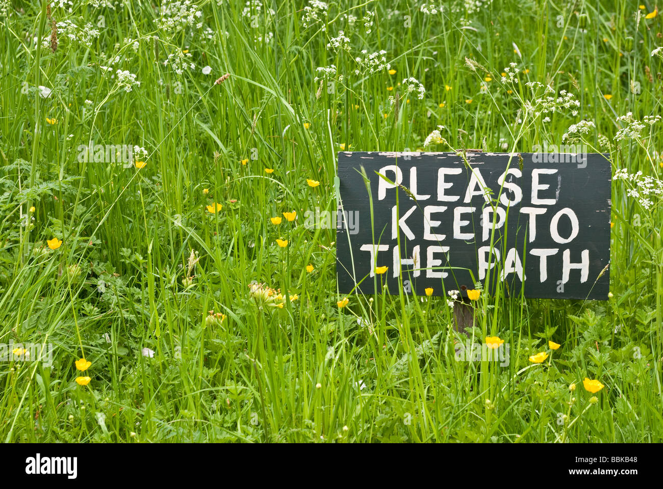 A sign asking people to keep to the path Stock Photo - Alamy