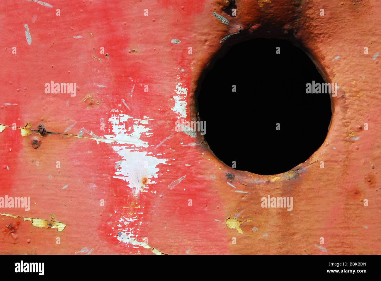 Hole in red steel panel, rusted and worn Stock Photo - Alamy