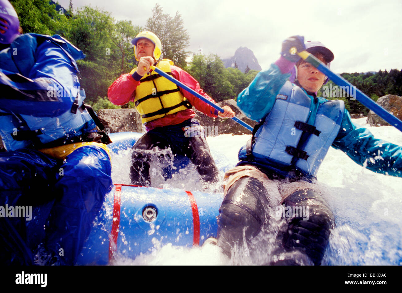 River rafters paddle fiercely to direct their raft through dangerous ...