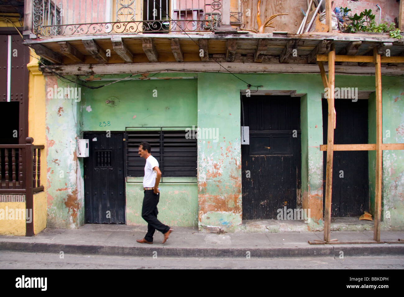 Man walking past house front in Santiago de Cuba Stock Photo - Alamy