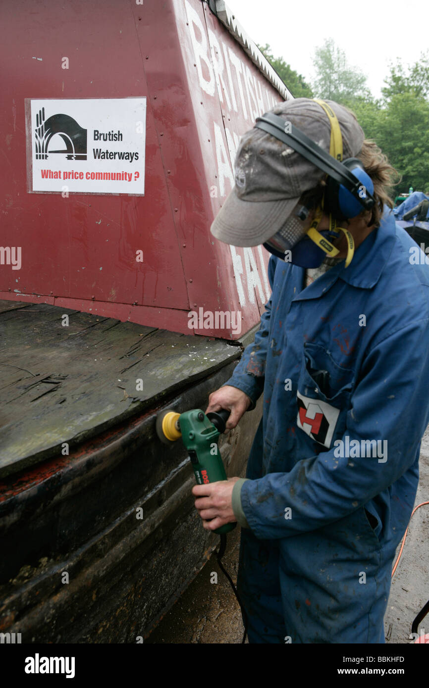 Ceri Fielding grinding of rust from the hull of his narrow boat Stock ...