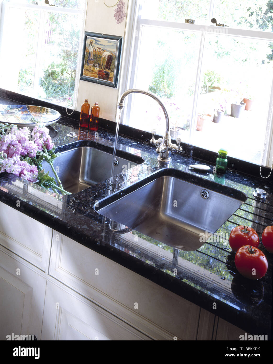 washing flowers in a modern all granite double sink Stock Photo - Alamy