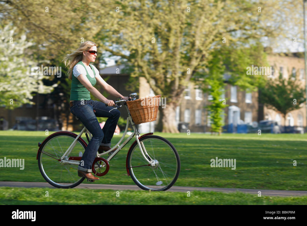 Girl Rides Bike across City Park Stock Photo - Alamy