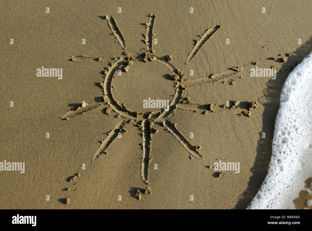 Symbol of a sun drawn in the sand Stock Photo - Alamy