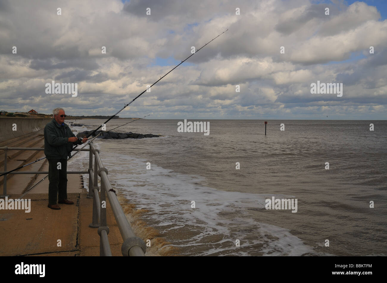 Man FIshing from the promenade at Southwold beach Suffolk Stock Photo ...