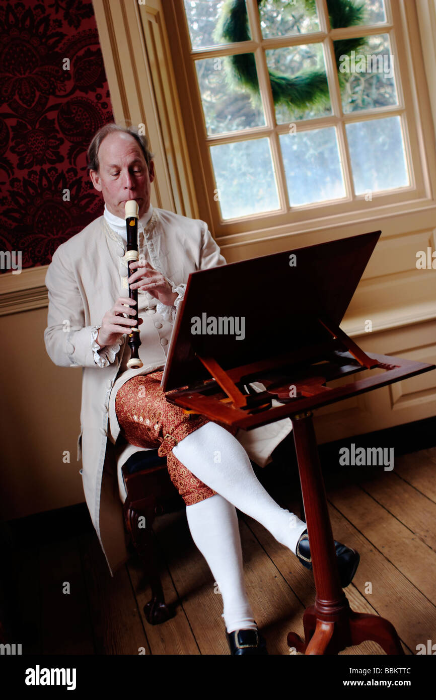 A costumed historical interpreter plays a recorder in Colonial ...