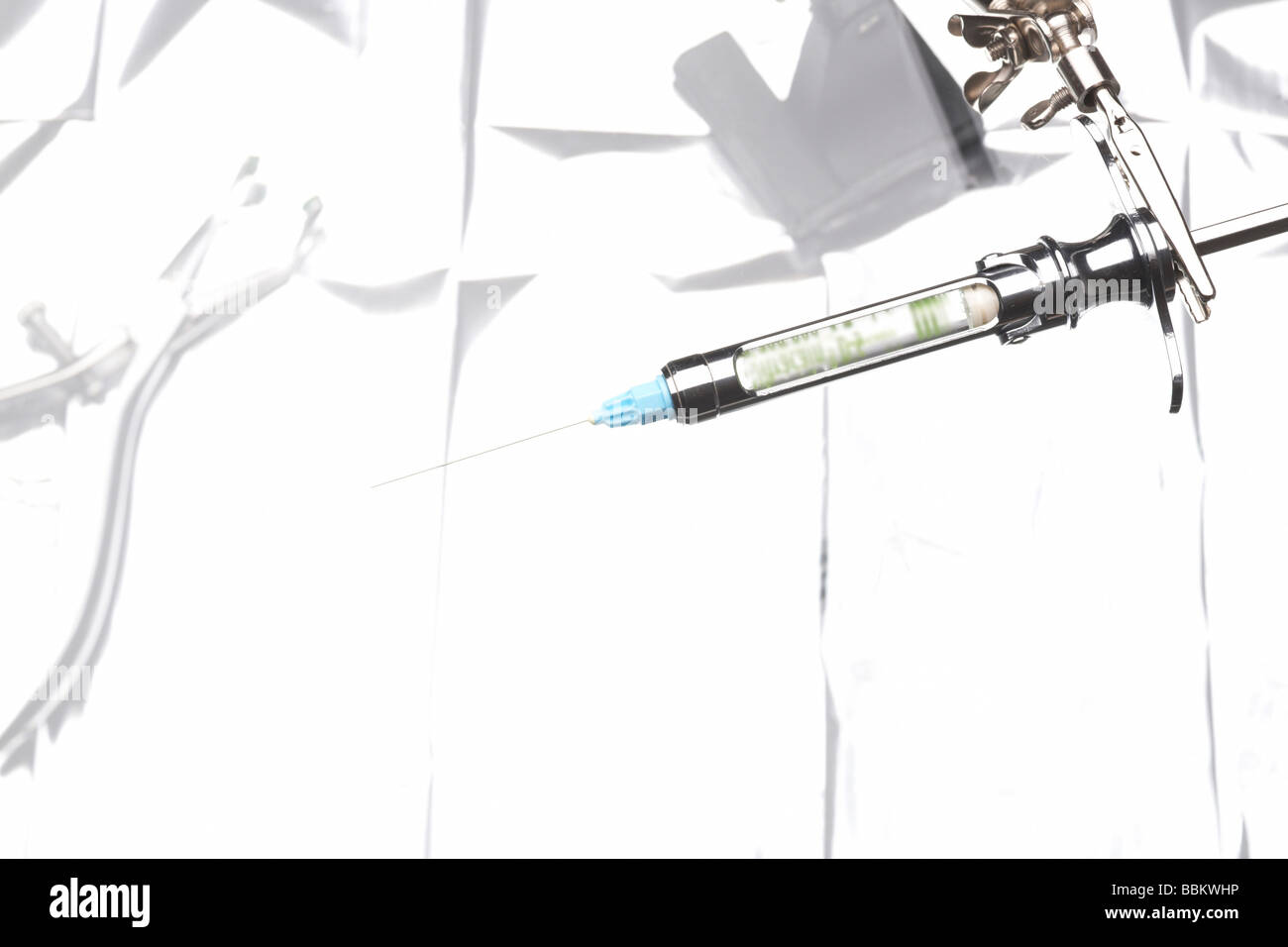 Injection syringe in a holding clamp, other tools Stock Photo - Alamy