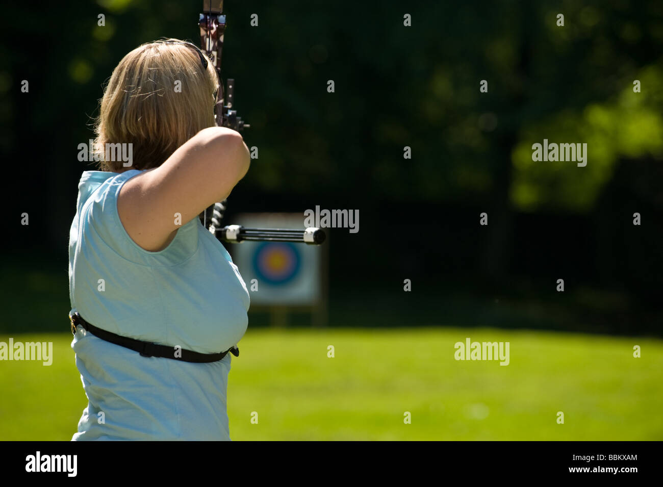 Girl shooting arrow from target bow Stock Photo - Alamy