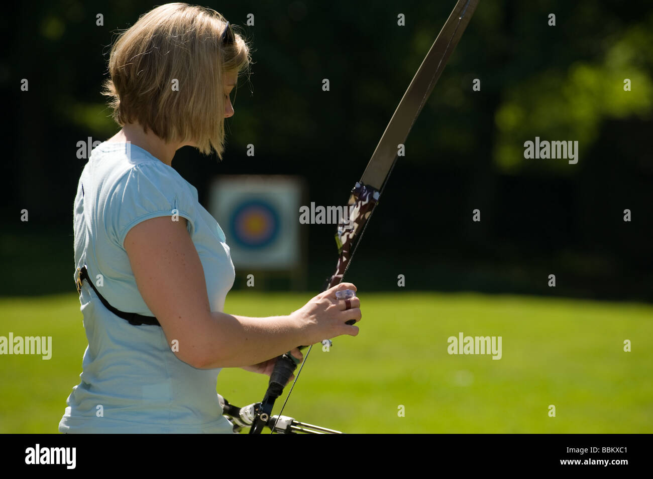 Girl preparing to shoot arrow from target bow Stock Photo - Alamy