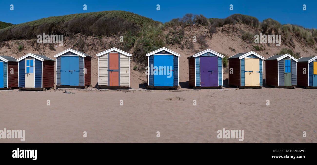 a row of beach huts on a sandy beach with sand dunes behind Stock Photo ...