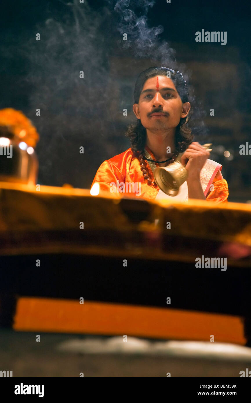 Young Indian male priest performing puja (Agni Pooja) at Dashashwamedh ...
