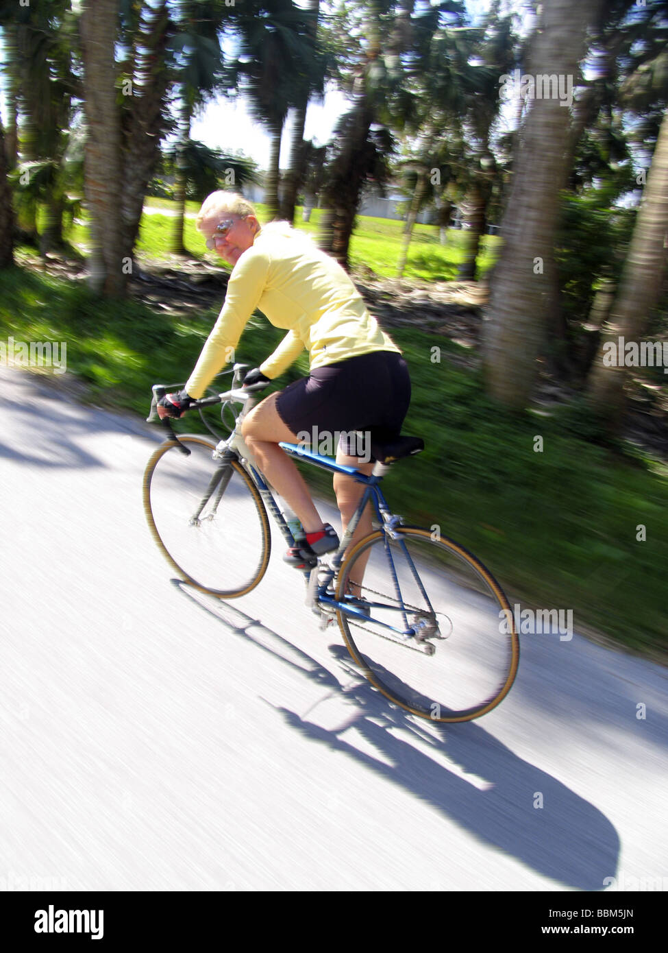 Female Cyclist riding racing bicycle Stock Photo - Alamy