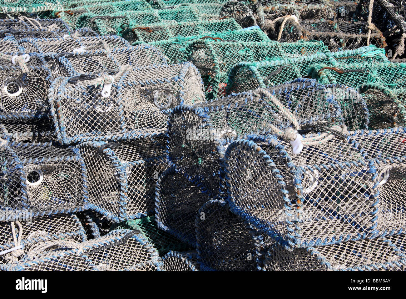 Lobster pots stacked on harbour quayside, Seahouses, Northumberland, UK ...