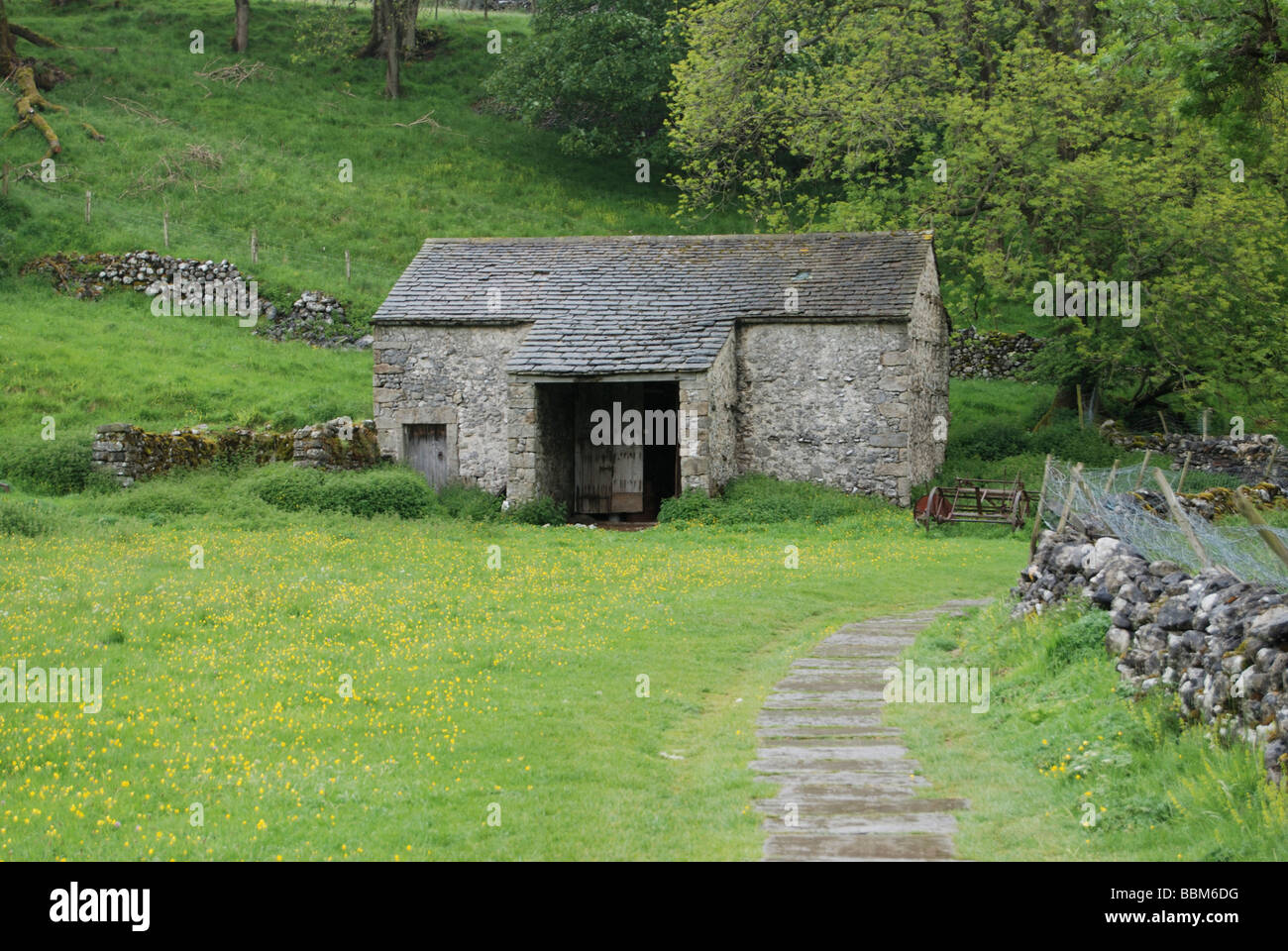 An old stone built farm building beside a footpath near Malham Village ...