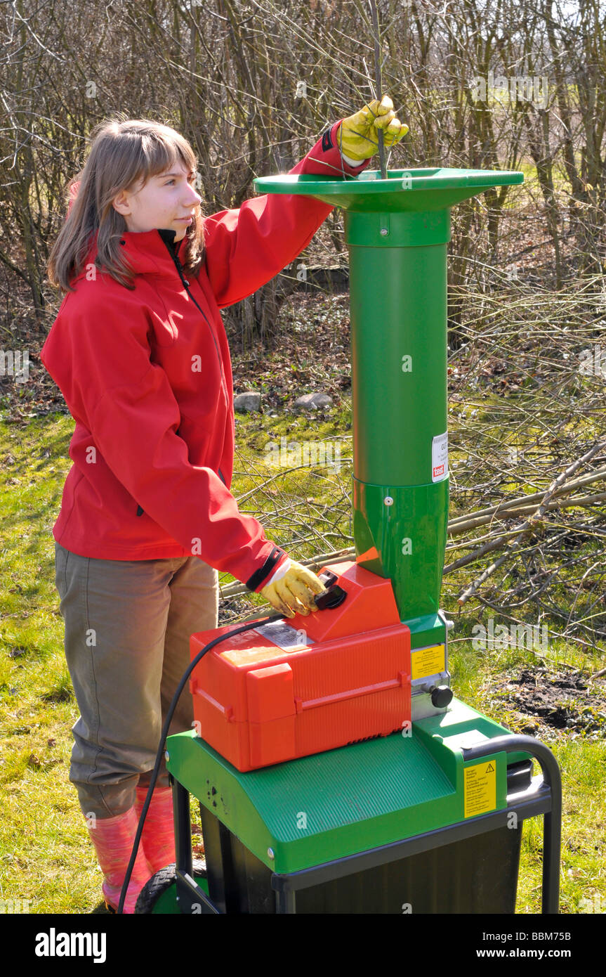 Girl shredding garden waste in a garden chopper Stock Photo - Alamy