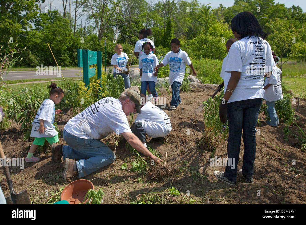Volunteers work on landscaping improvements at an entrance to Rouge ...