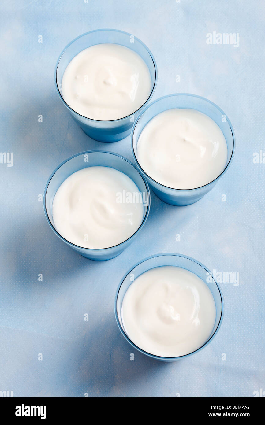 Four blue cups of yoghurt Stock Photo - Alamy
