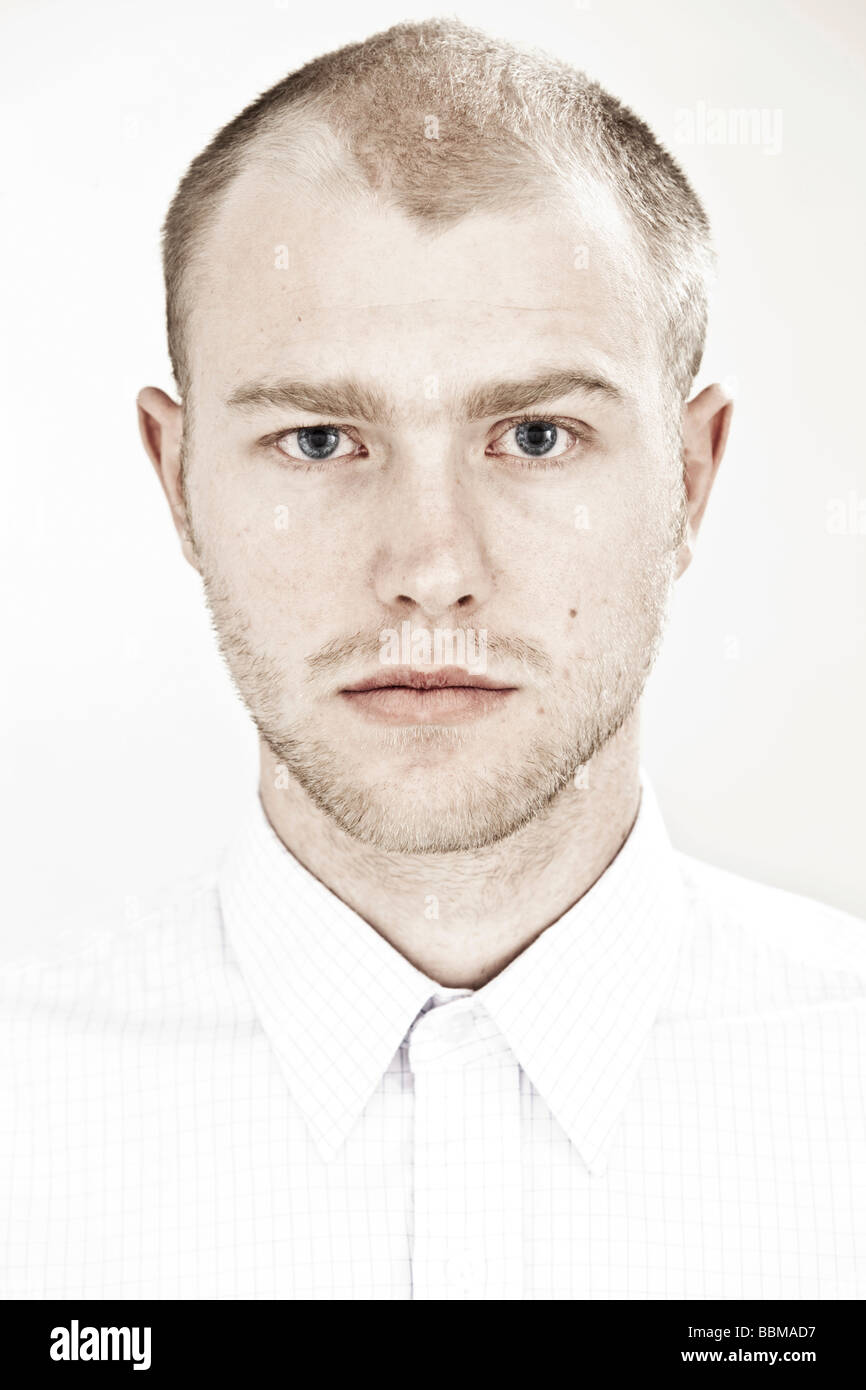 Portrait of a young man looking stern Stock Photo - Alamy