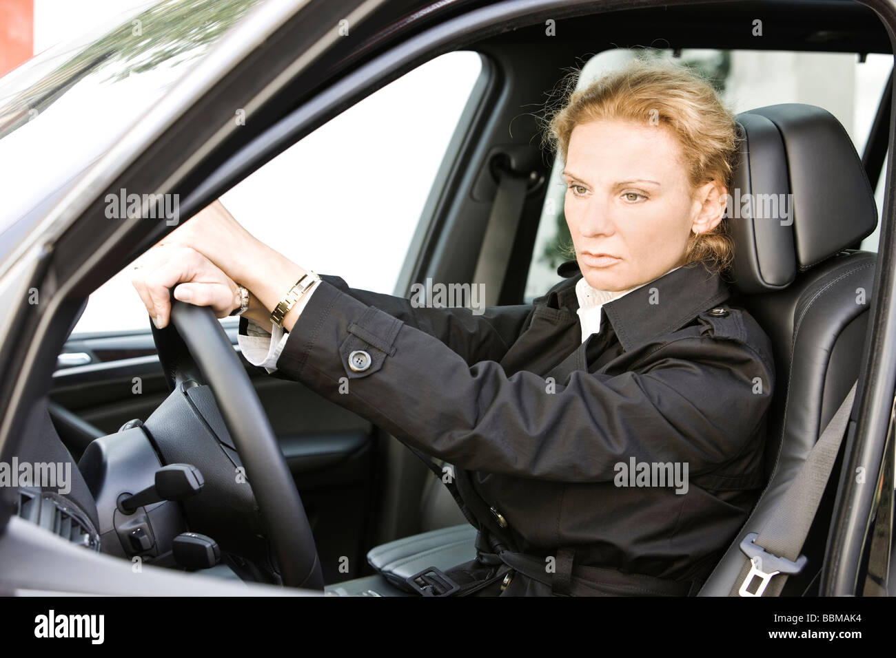 Woman behind the steering wheel of a luxury cross country vehicle ...