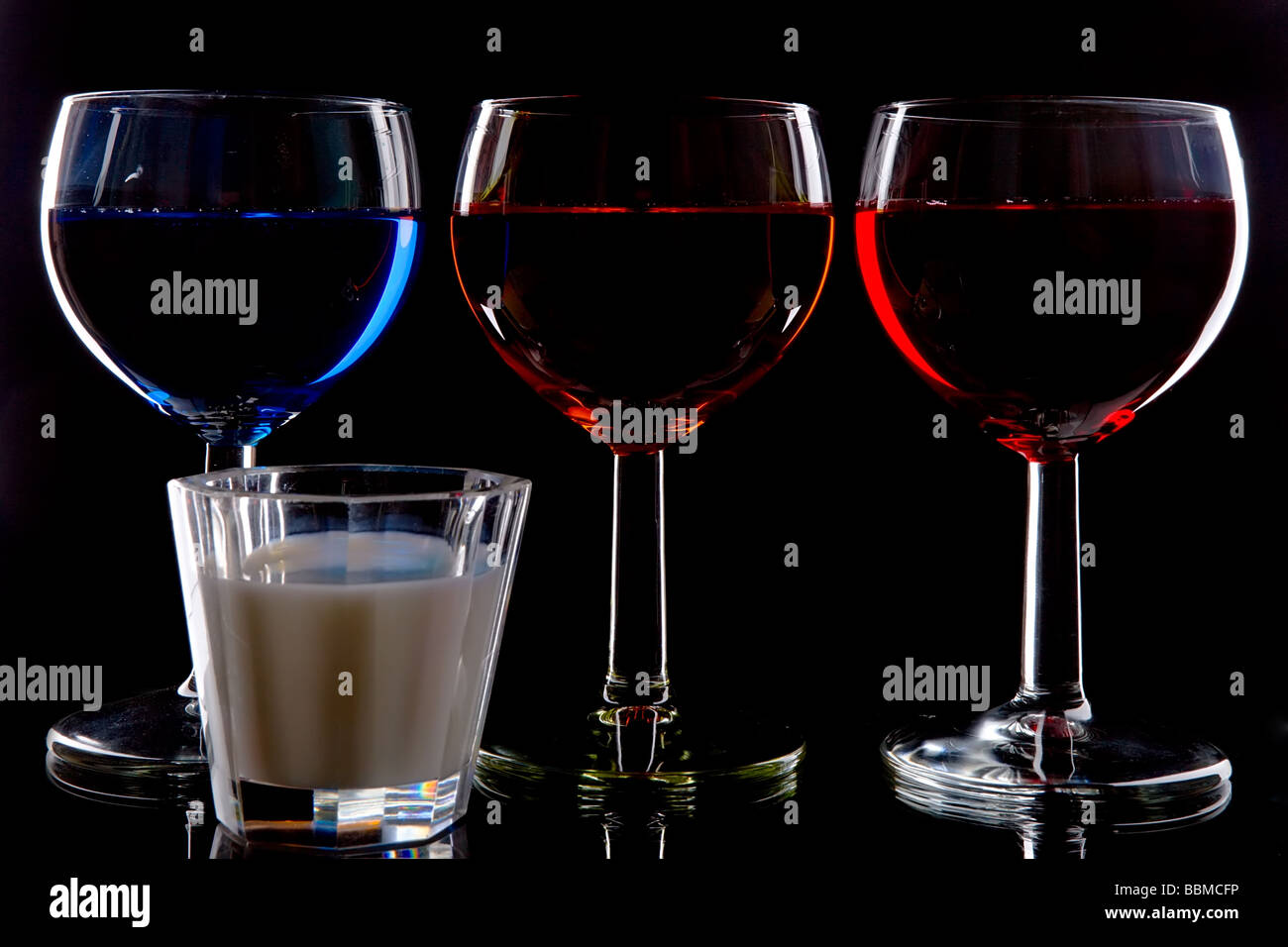 Three glasses with color drinks and glass with milk Stock Photo - Alamy