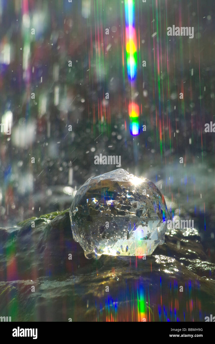 Glass crystal in waterfall with coloured light rays Stock Photo - Alamy