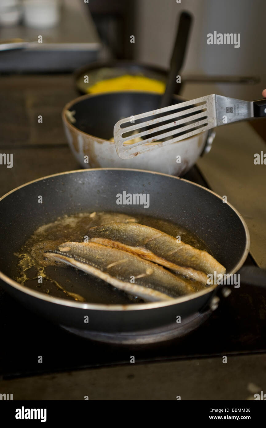 A chef cooks sea-bass in the kitchen Stock Photo - Alamy