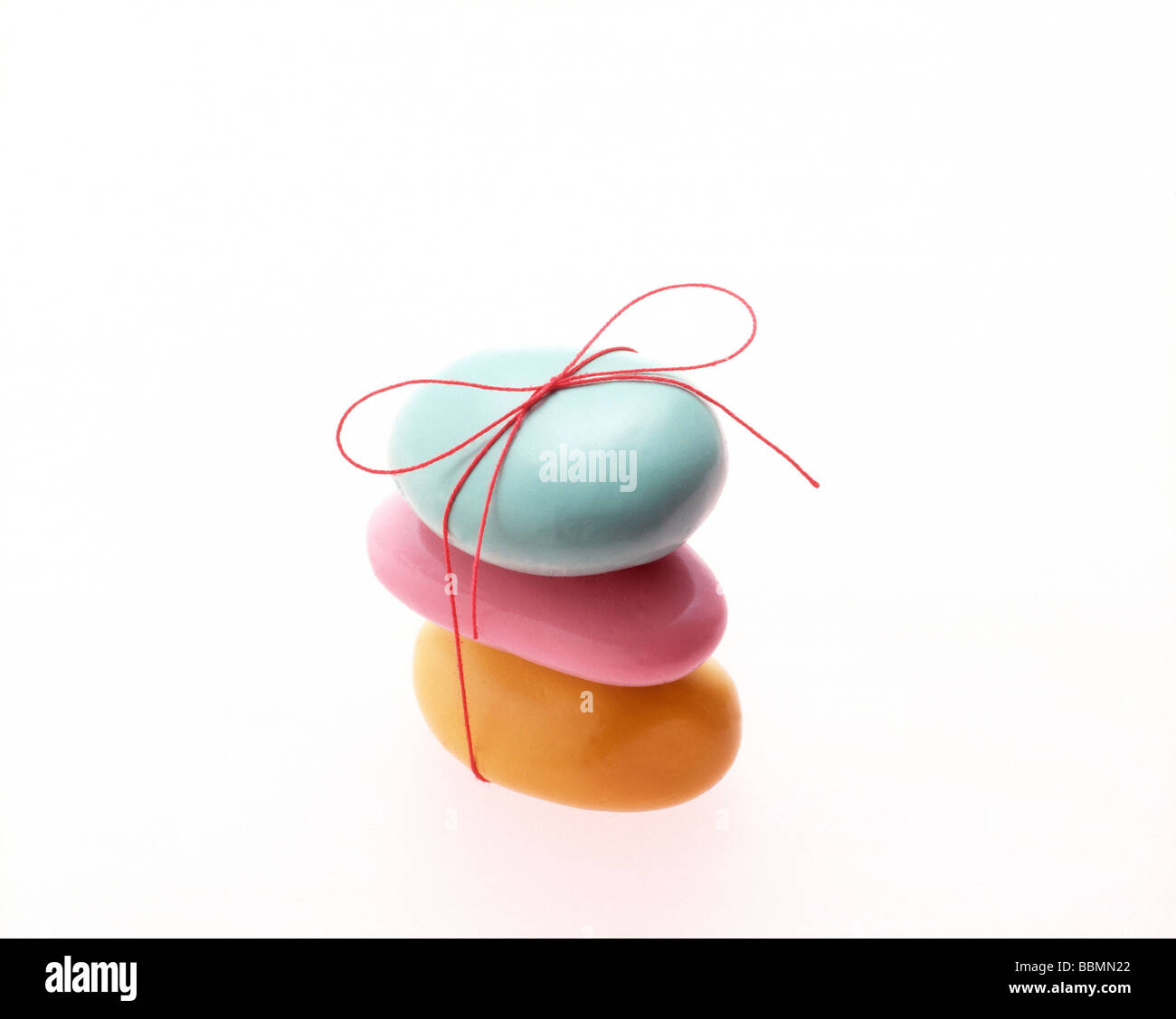 Pebbles tied up with string on white background, close-up Stock Photo ...