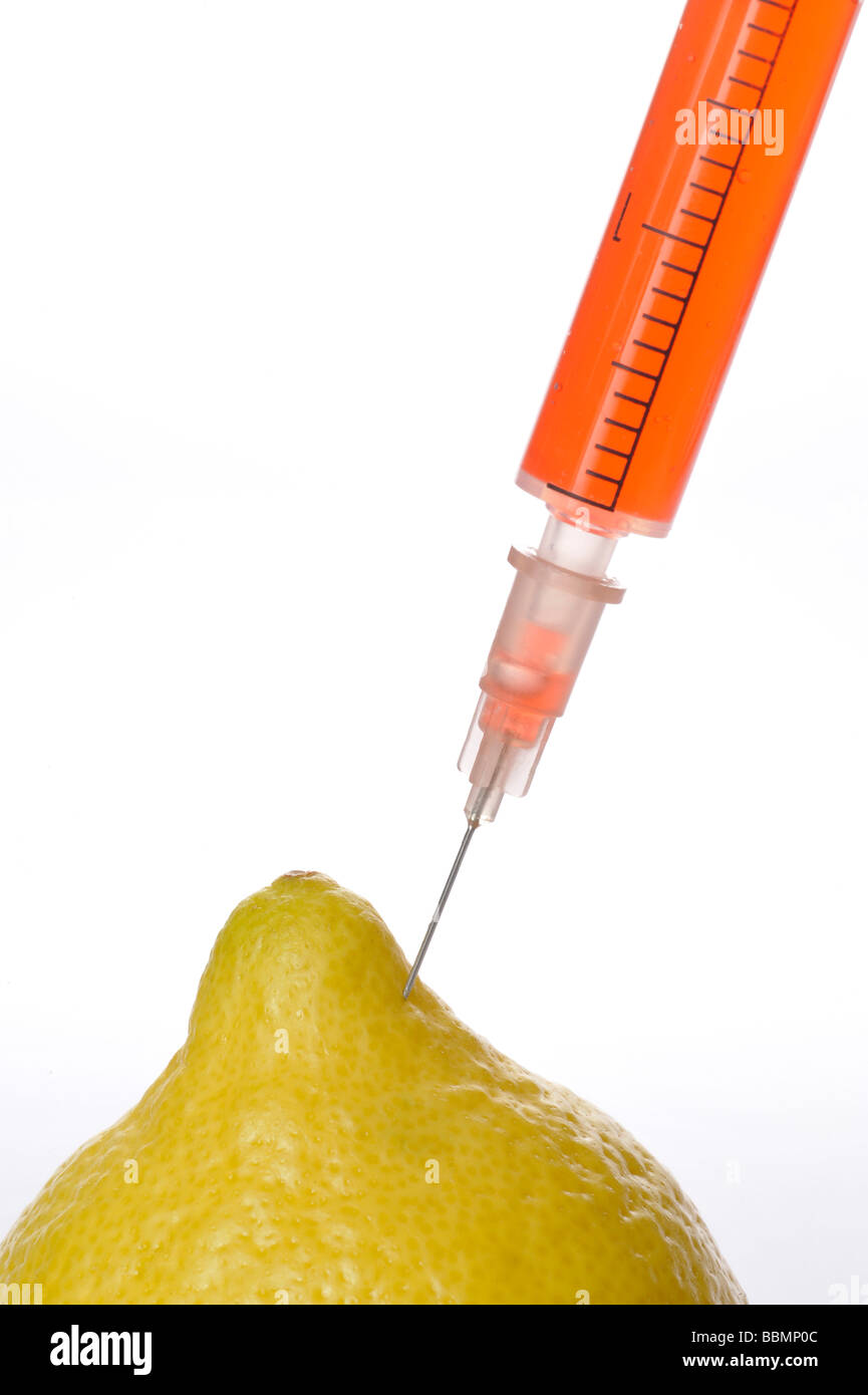 Syringe in lemon, symbolic picture, genetically modified foods Stock ...