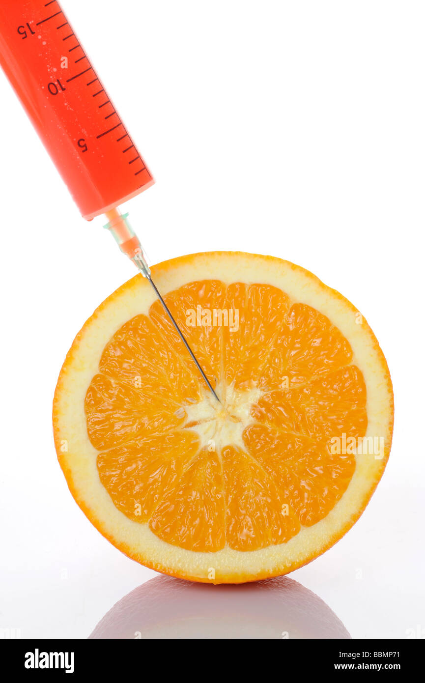 Syringe in orange, symbolic picture, genetically modified foods Stock ...