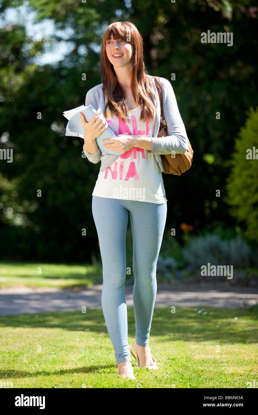 Girl walking with books Stock Photo - Alamy